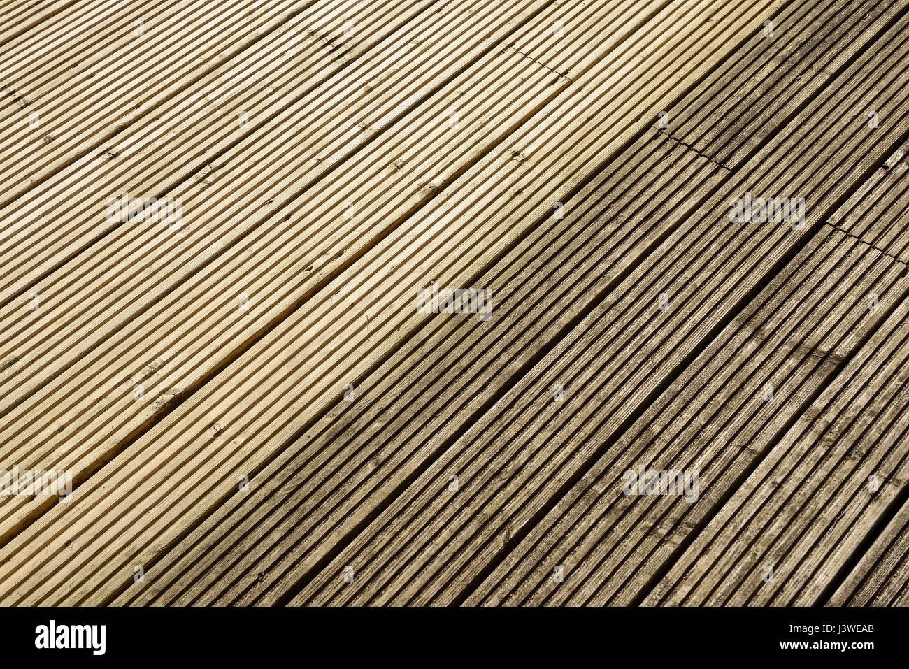 Wooden decking half way through being cleaned and revived Stock Photo ...