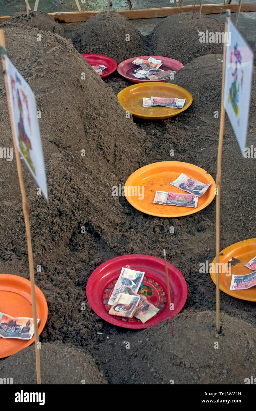 Plates containing money rest in sand during a Khmer New Year ...