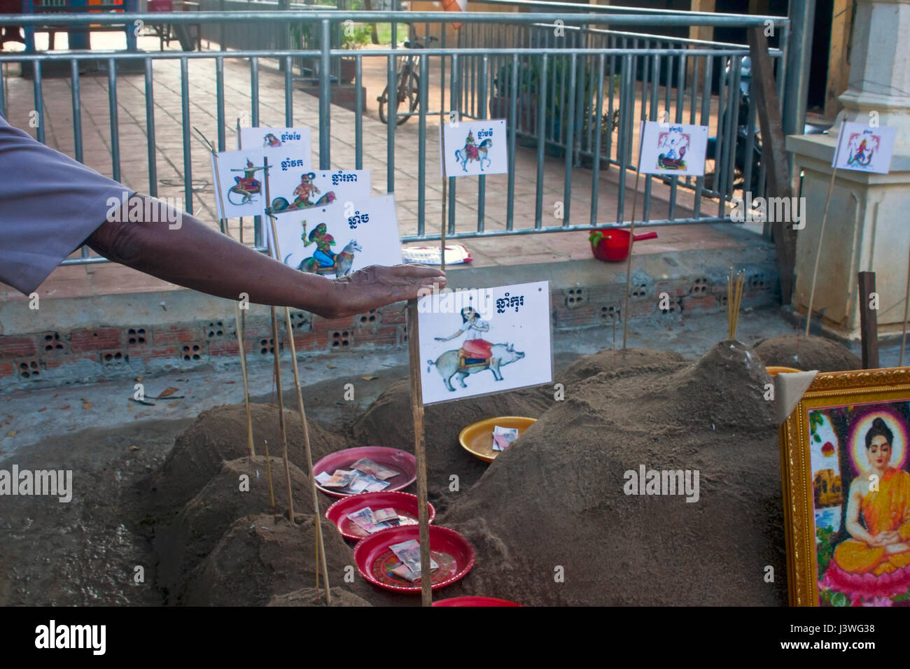 Plates containing money rest in sand during a Khmer New Year ...