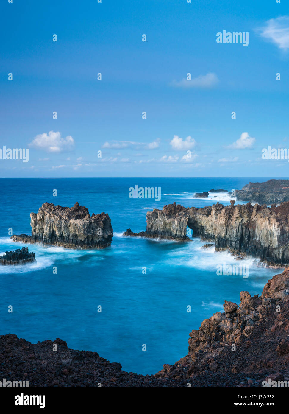 Sea arch and sea stacks of massive and columnar jointed basaltic lava ...