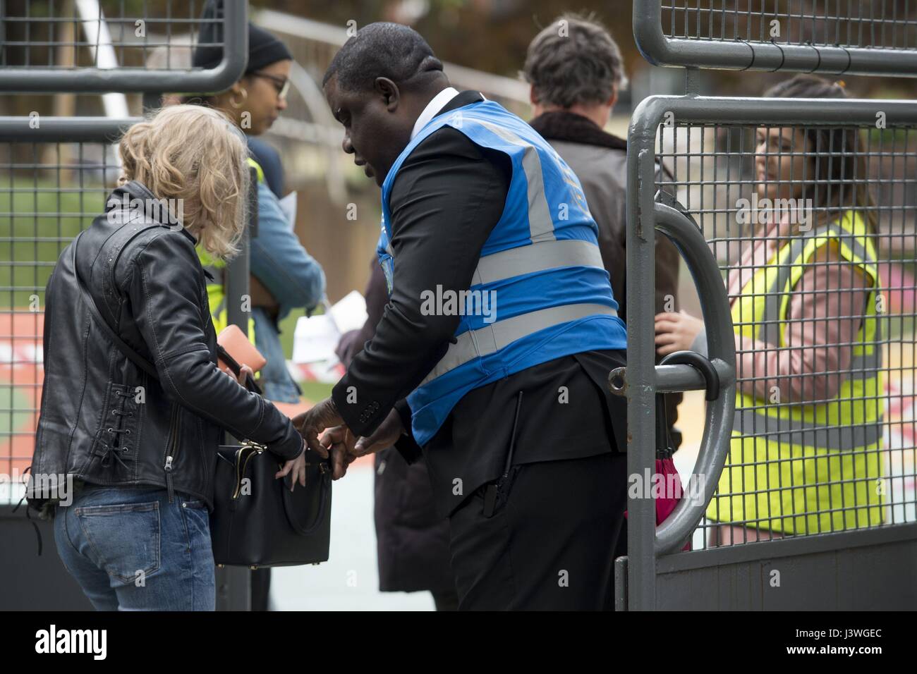 French voters have their bags checked by a security guard before ...