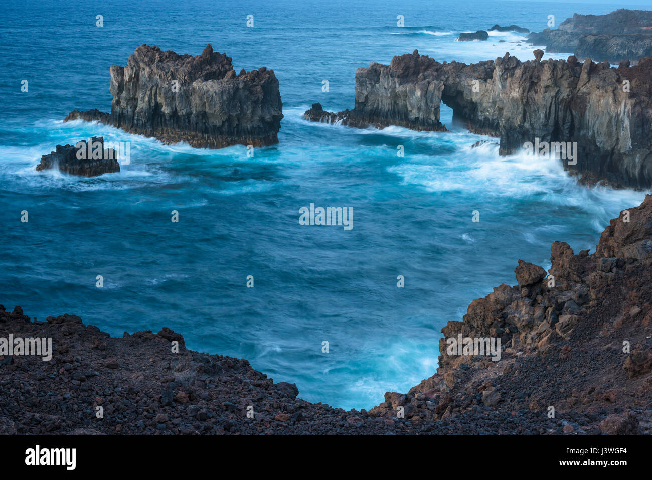 Sea arch and sea stacks of massive and columnar jointed basaltic lava ...