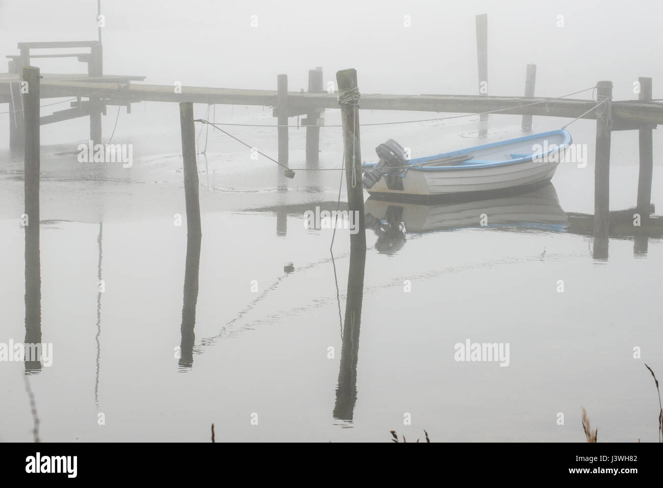 Boat and jetty in mist Stock Photo - Alamy