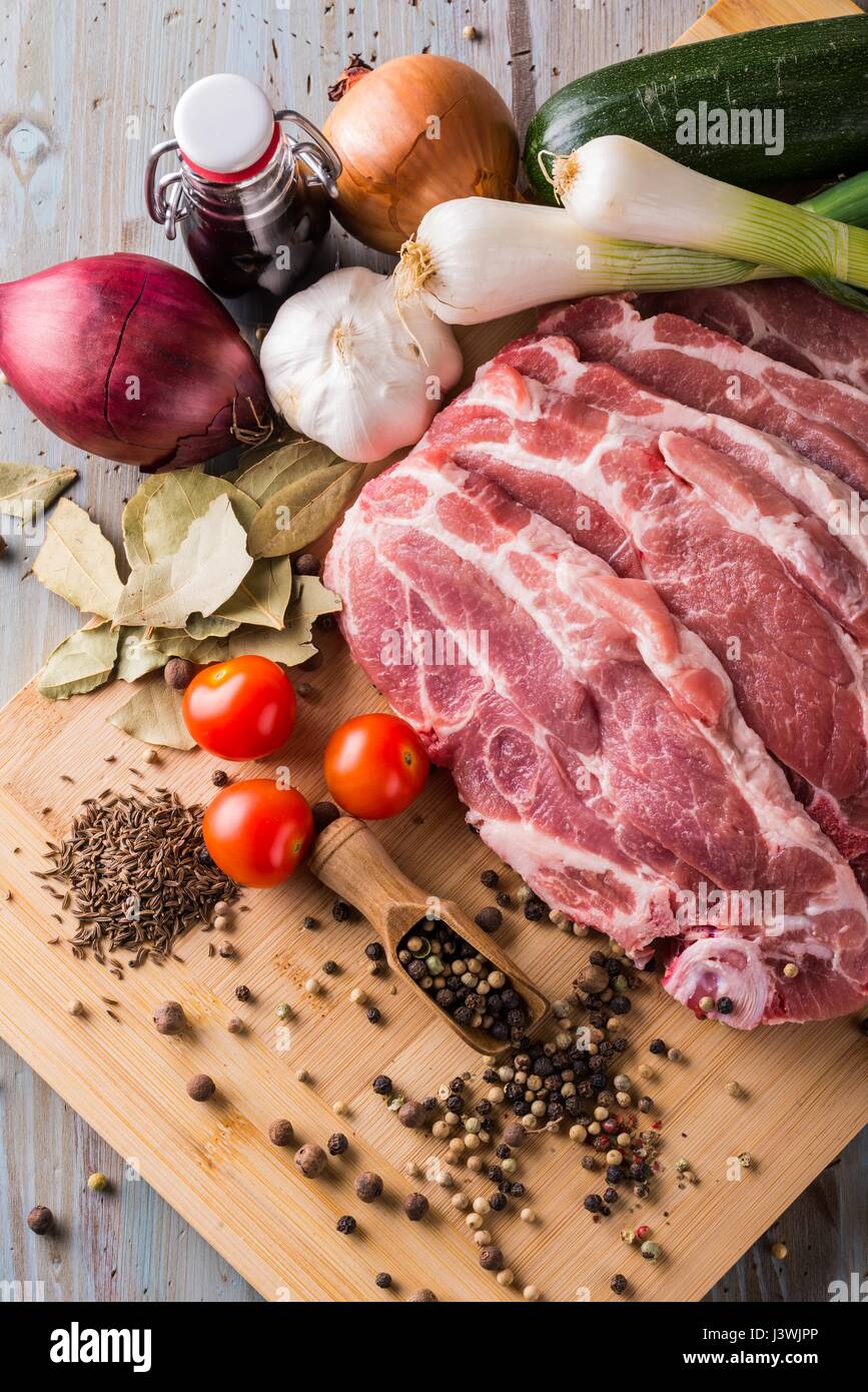 Vertical photo of several slices of neck pork stakes with fat. Meat is ...