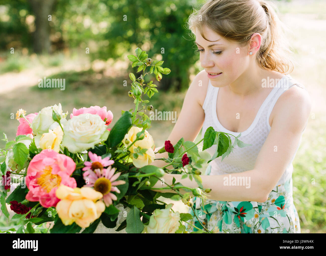 bouquet, people and floral arrangement concept - young woman making ...