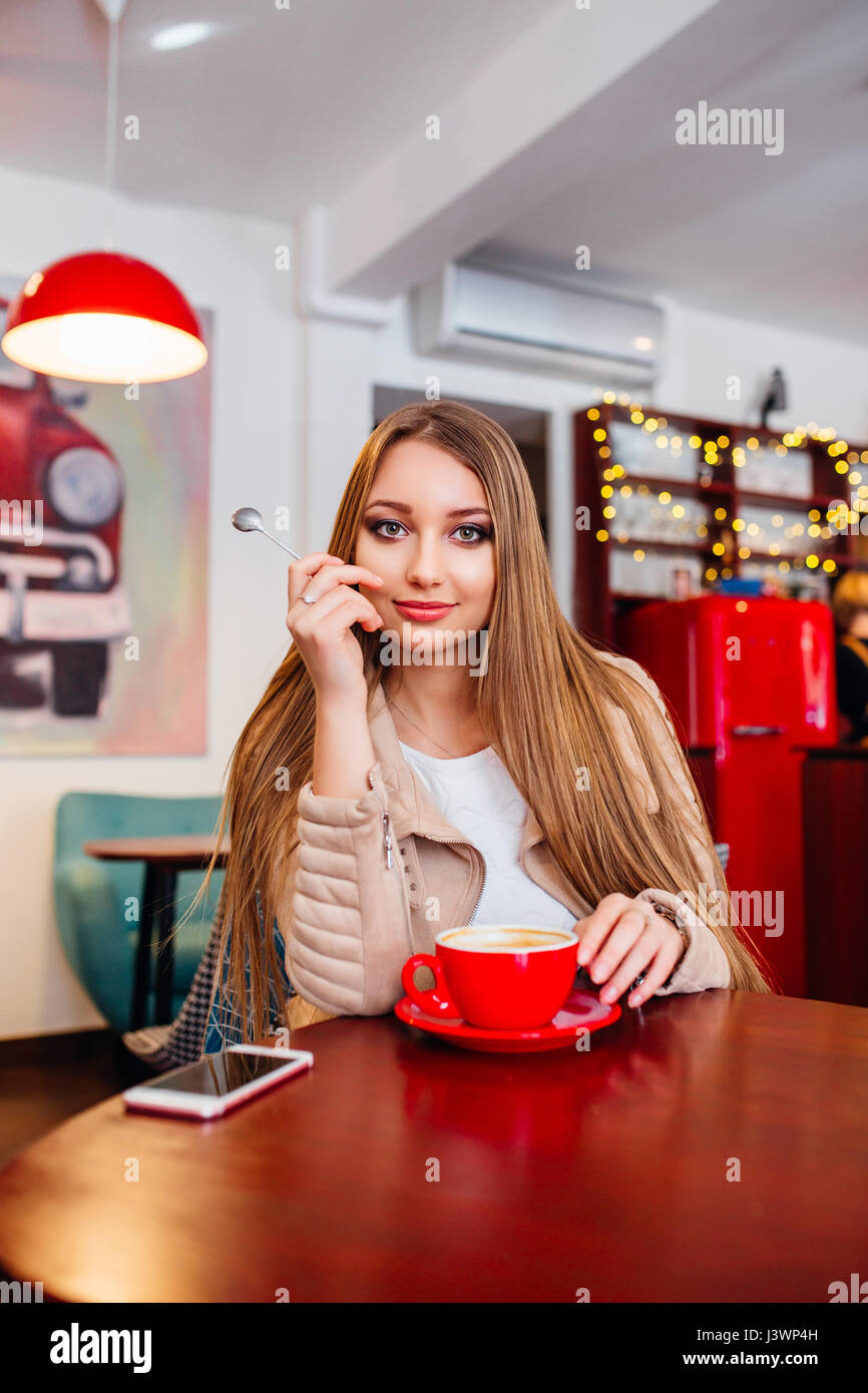 Beautiful cute girl in the cafe with coffee smiling Stock Photo - Alamy