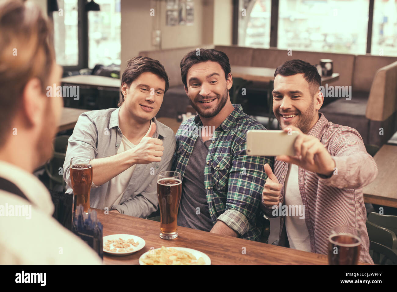 Friends having fun in pub Stock Photo - Alamy