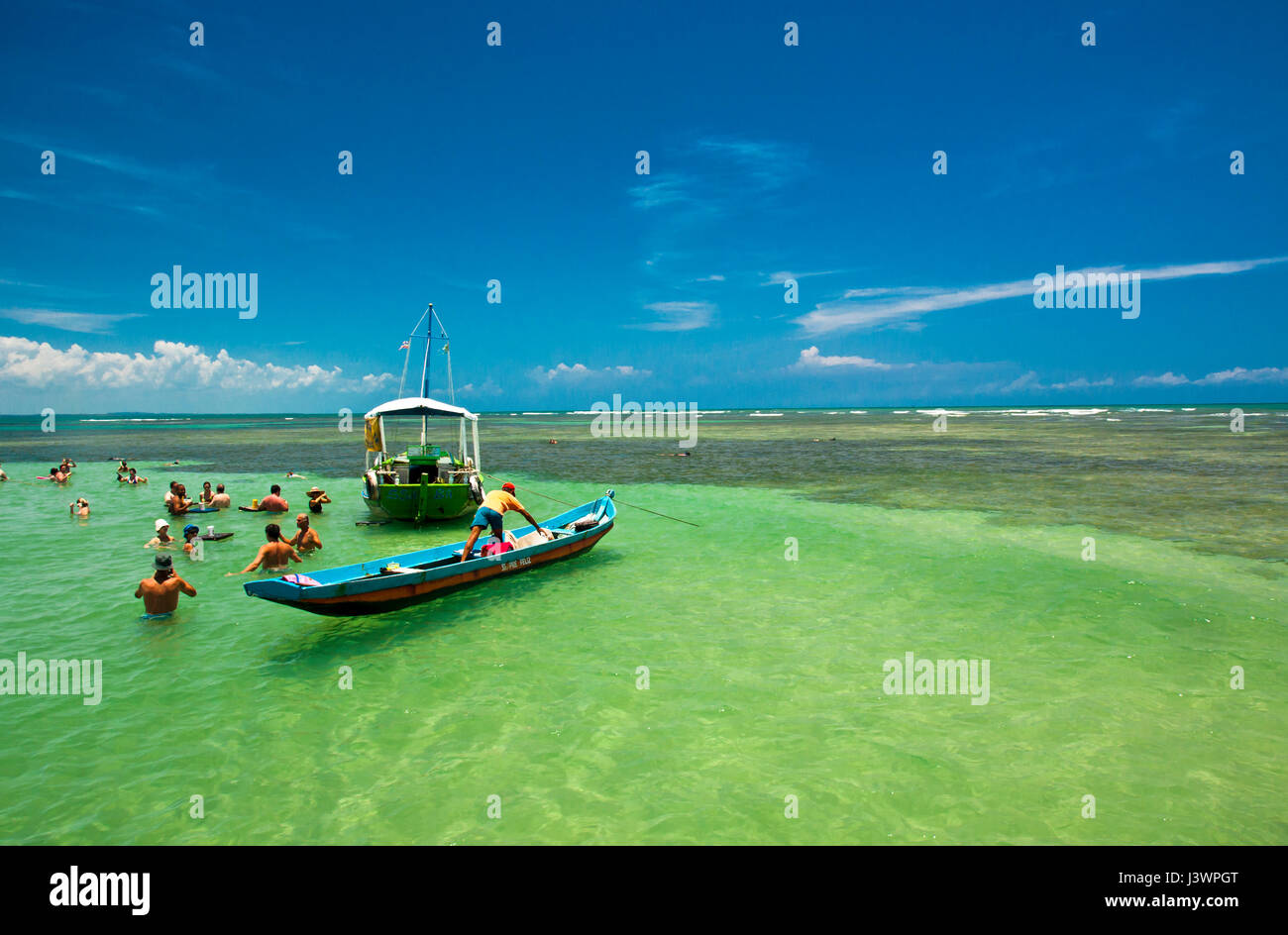 tourist celebrating with drinks at a natural pool at Boipeba, brazil ...