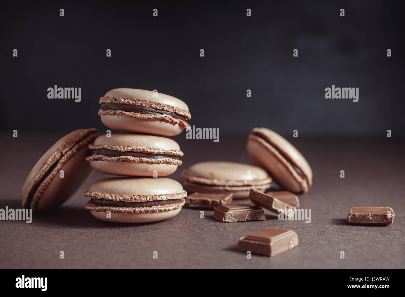 Stack of Chocolate pastel brown Macarons or Macaroons over dark ...