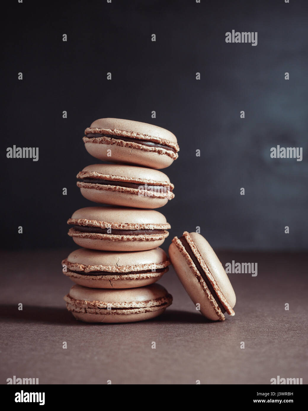 Stack of Chocolate pastel brown Macarons or Macaroons over dark ...