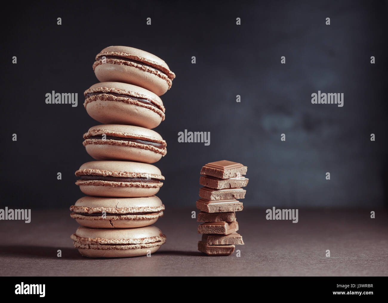 Stack of Chocolate pastel brown Macarons or Macaroons over dark ...