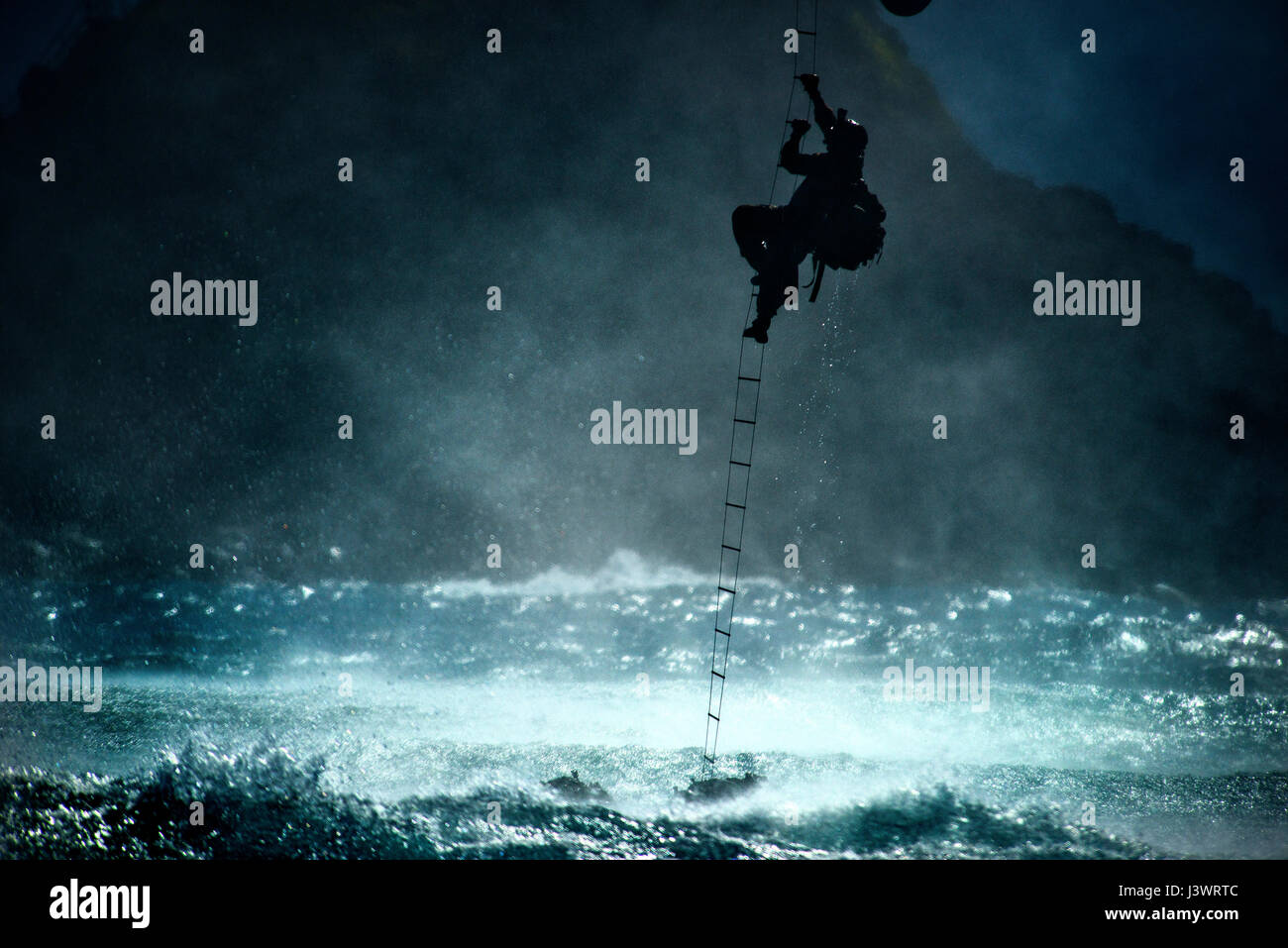 A USAF special operations airman climbs up an assault ladder onto a U.S ...