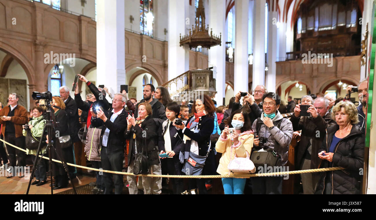 Tourists take photographs of the St. Thomas Choir of Leipzig during a ...