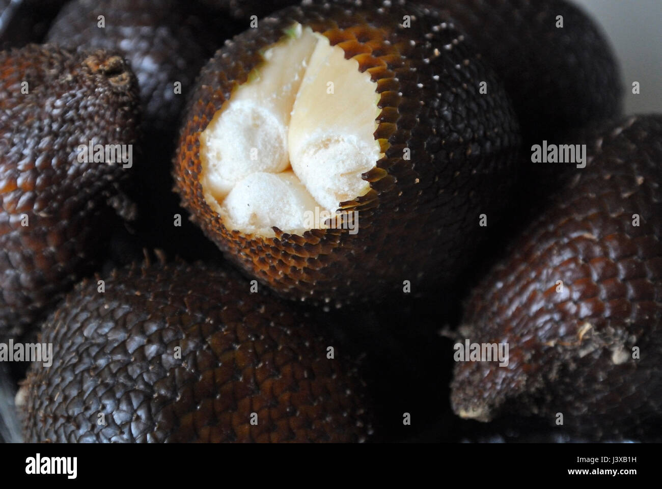 Salak, or snake fruit, in a pile showing the scaly skin that gives it ...