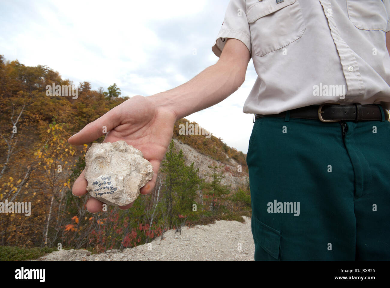 Ranger shows fossil shells embedded in the rock, Riding Mountain ...