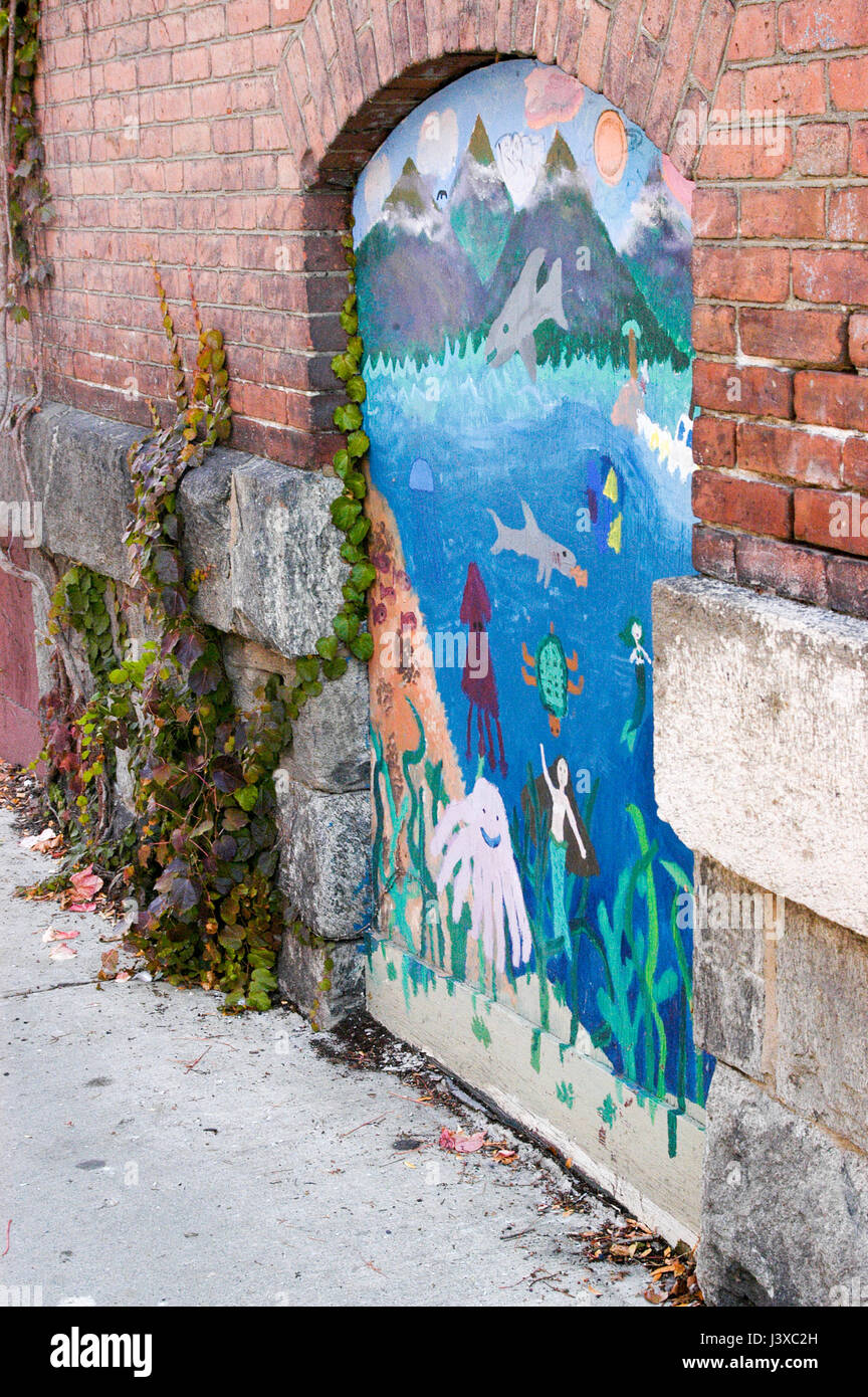 A painted alcove in a brick building covered in vines. The street art ...