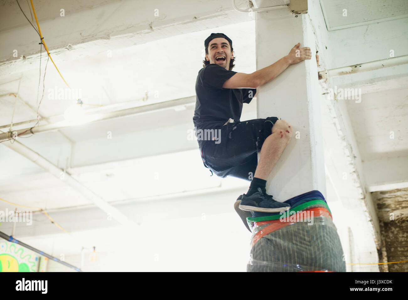 Young man climbing Stock Photo - Alamy