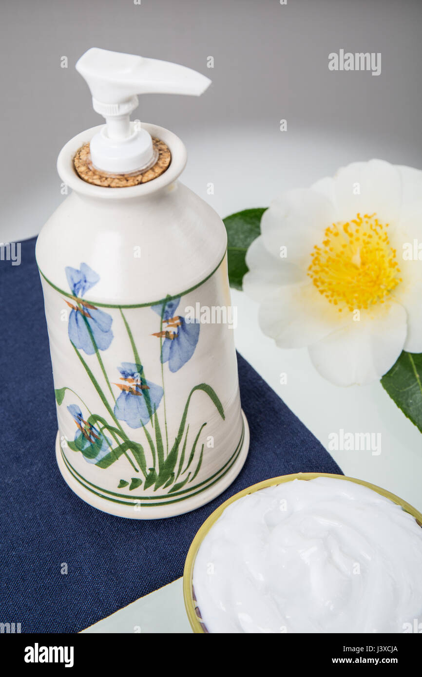 Lotion in an attractive pottery container surrounded by a bowl of ...