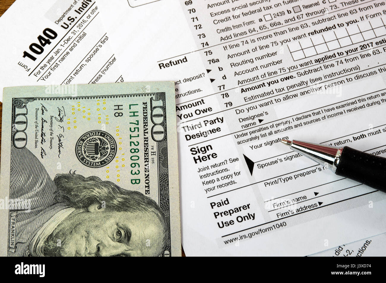 ink pen and money on 1040 income tax form Stock Photo - Alamy