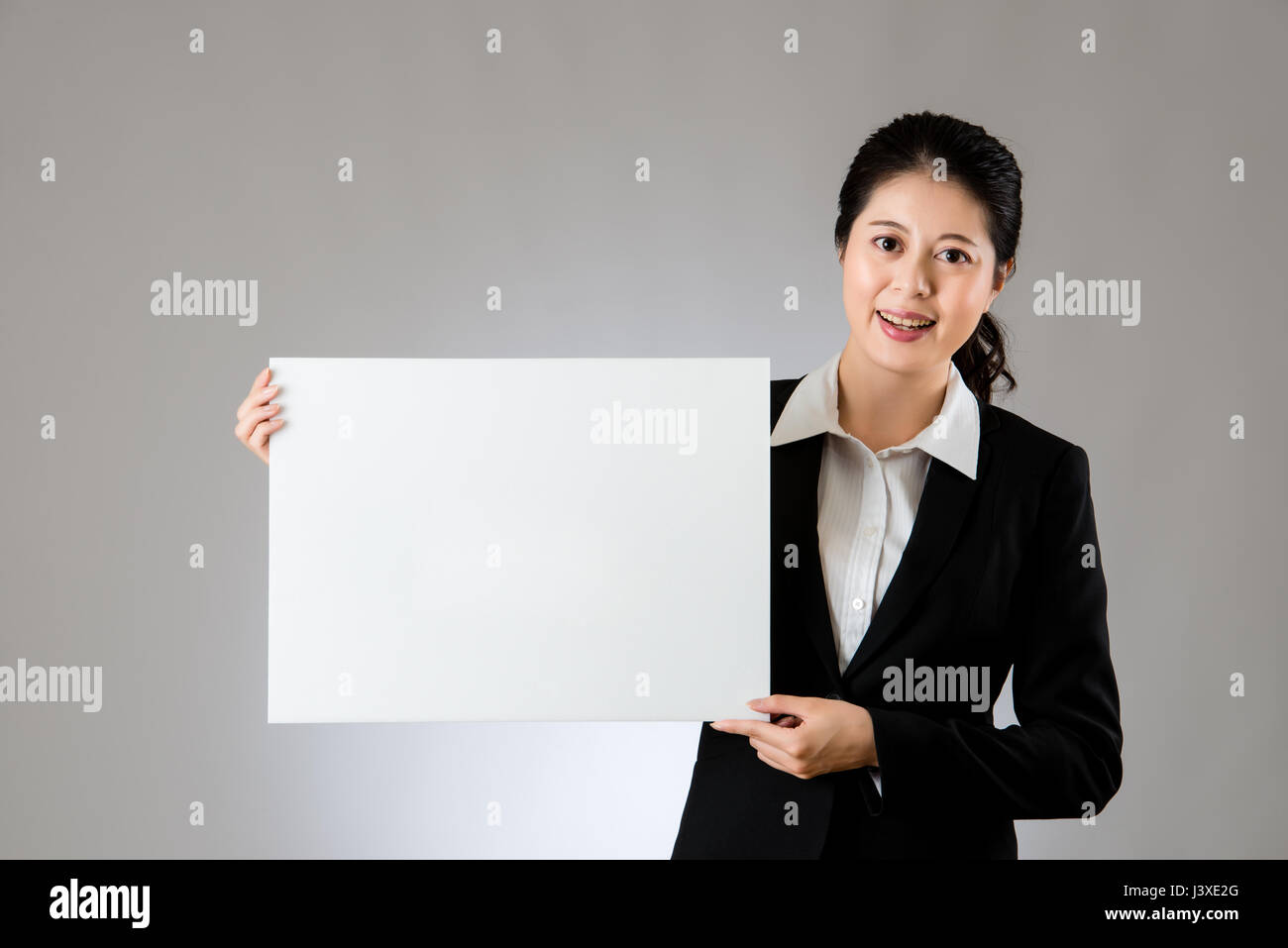 smiling beautiful business woman holding blank sign paper board ...