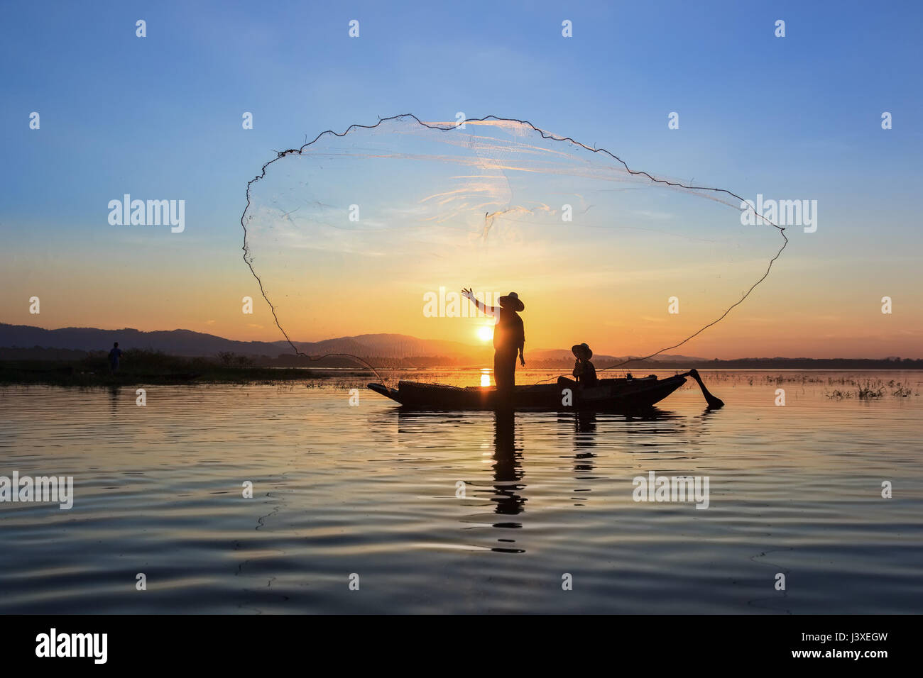 Silhouette fisherman on fishing boat setting net with sunrise Stock ...