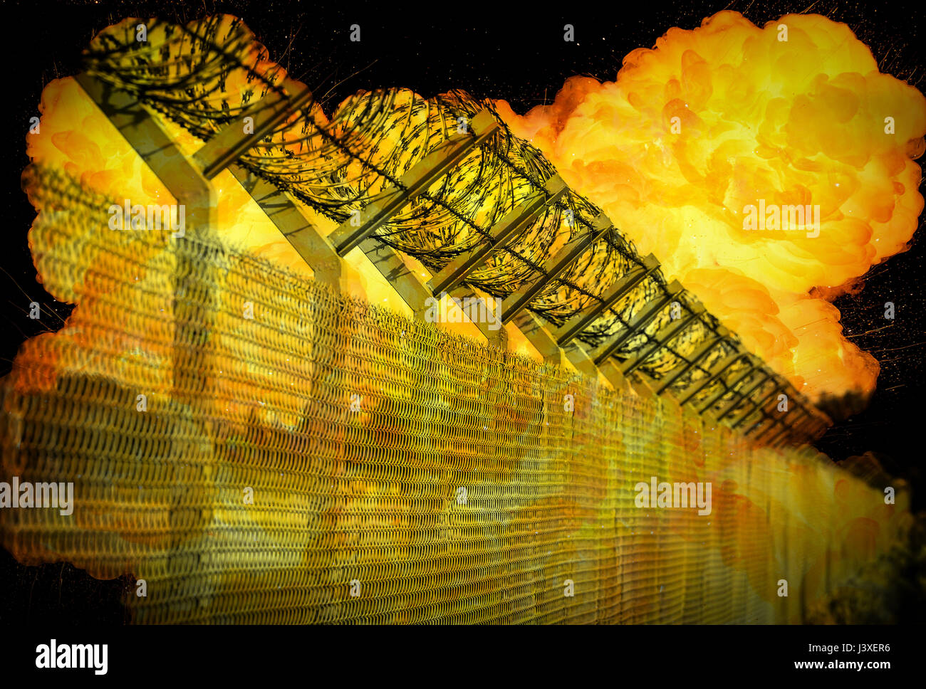 Realistic orange fire explosion behind restricted area barbed wire ...