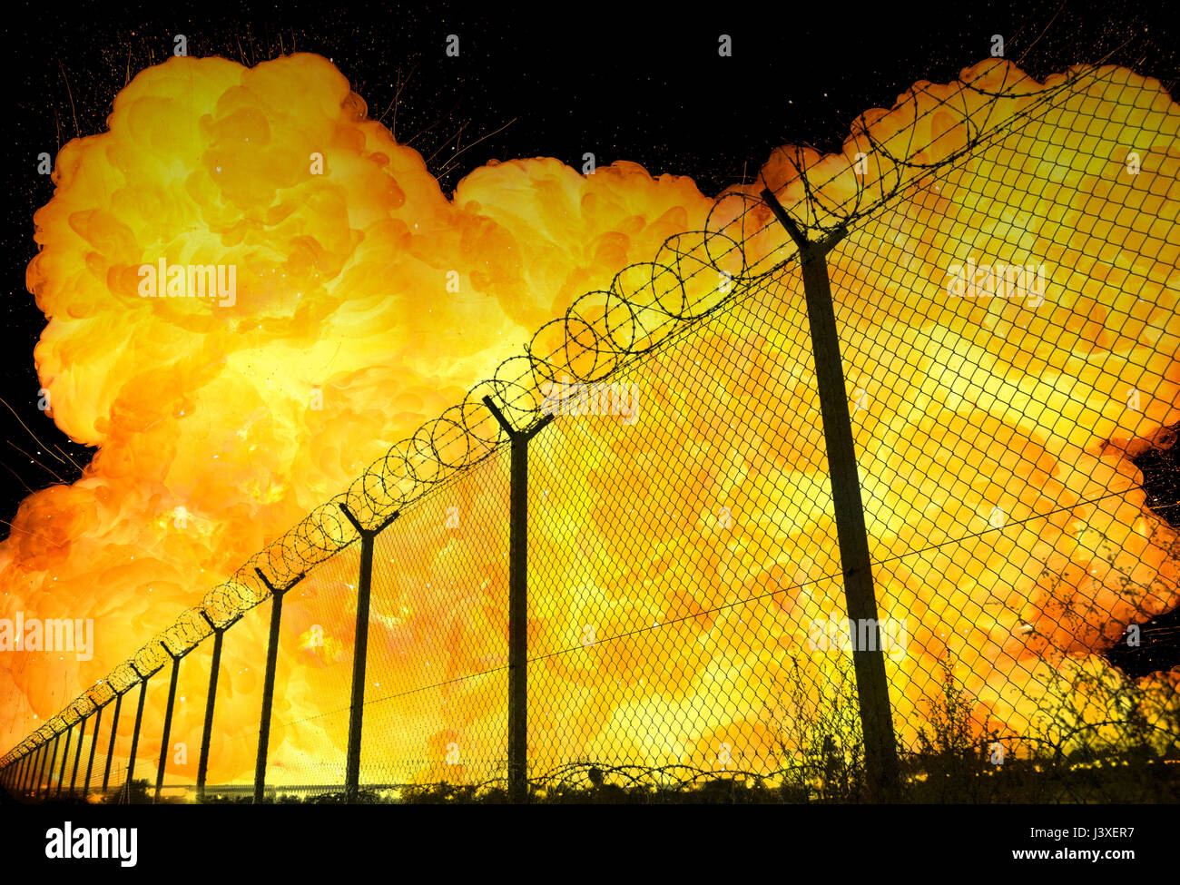 Realistic orange fire explosion behind restricted area barbed wire ...