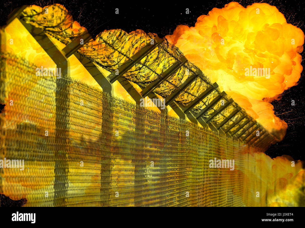 Realistic orange fire explosion behind restricted area barbed wire ...