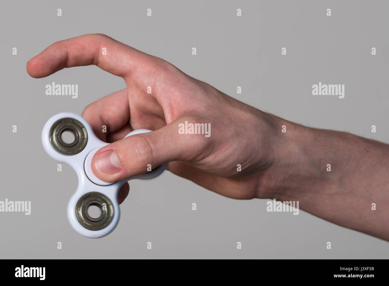 Young boy playing with fidget spinner toy to relieve stress isolated ...