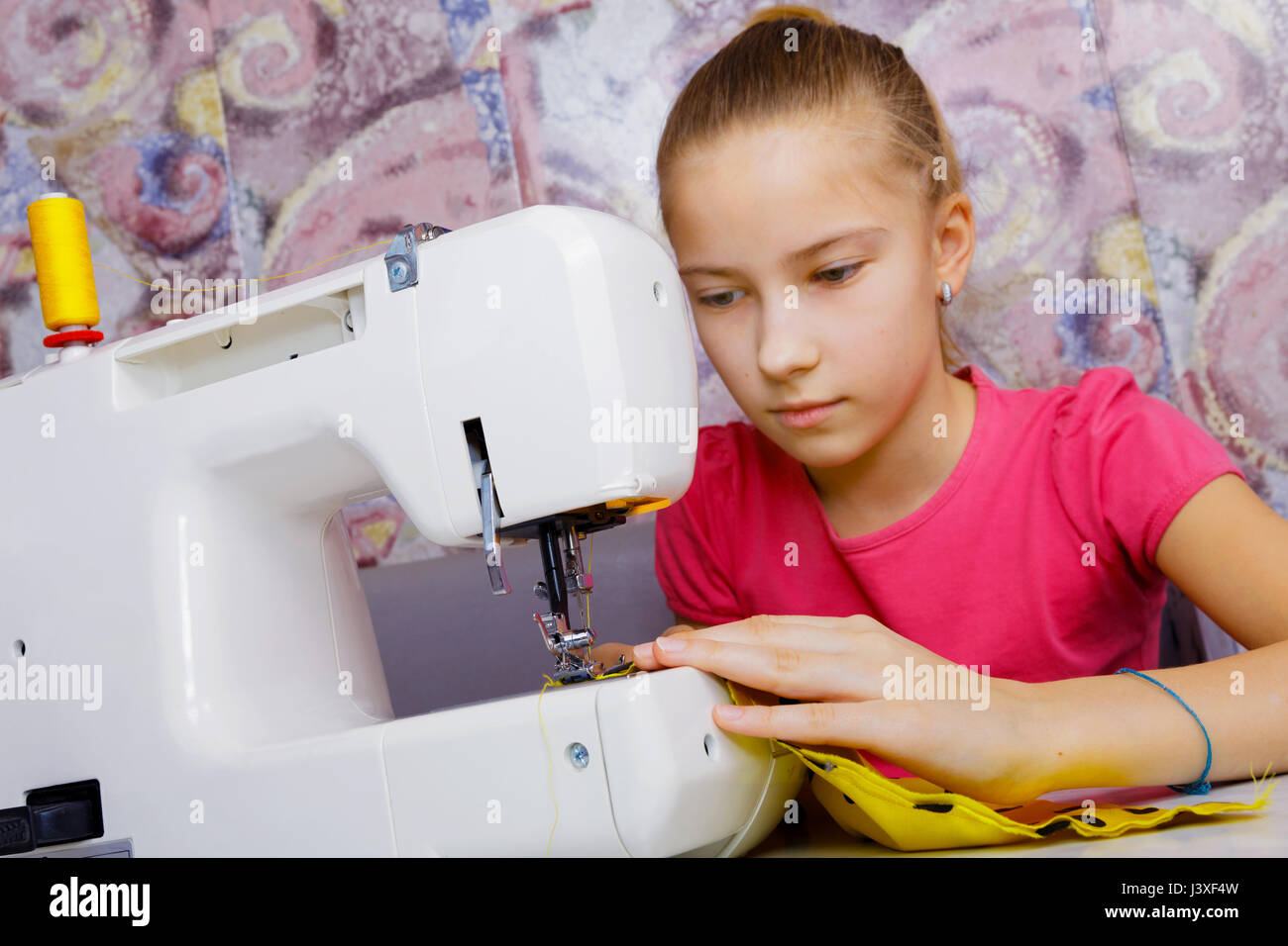 A teenage girl diligently learns to sew Stock Photo - Alamy