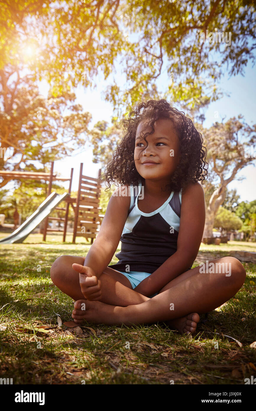 Portrait of young girl sitting on grass Stock Photo - Alamy