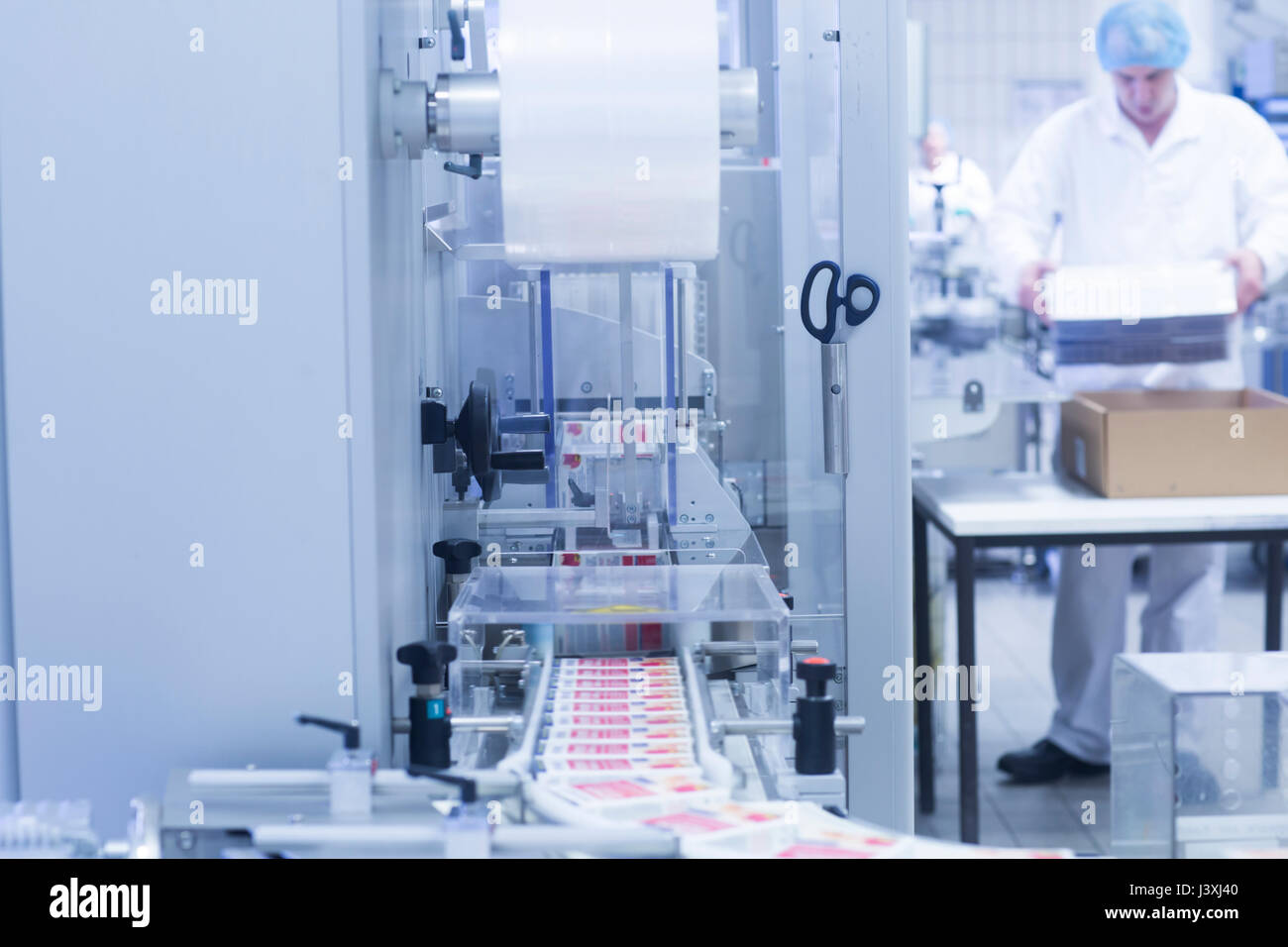 Workers packaging pharmaceutical products on production line in ...