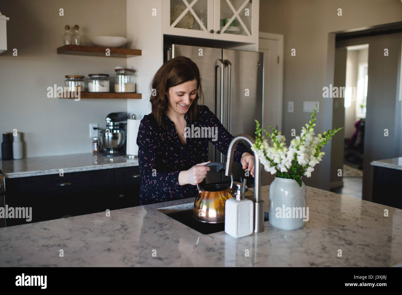 Woman filling kettle up hi-res stock photography and images - Alamy