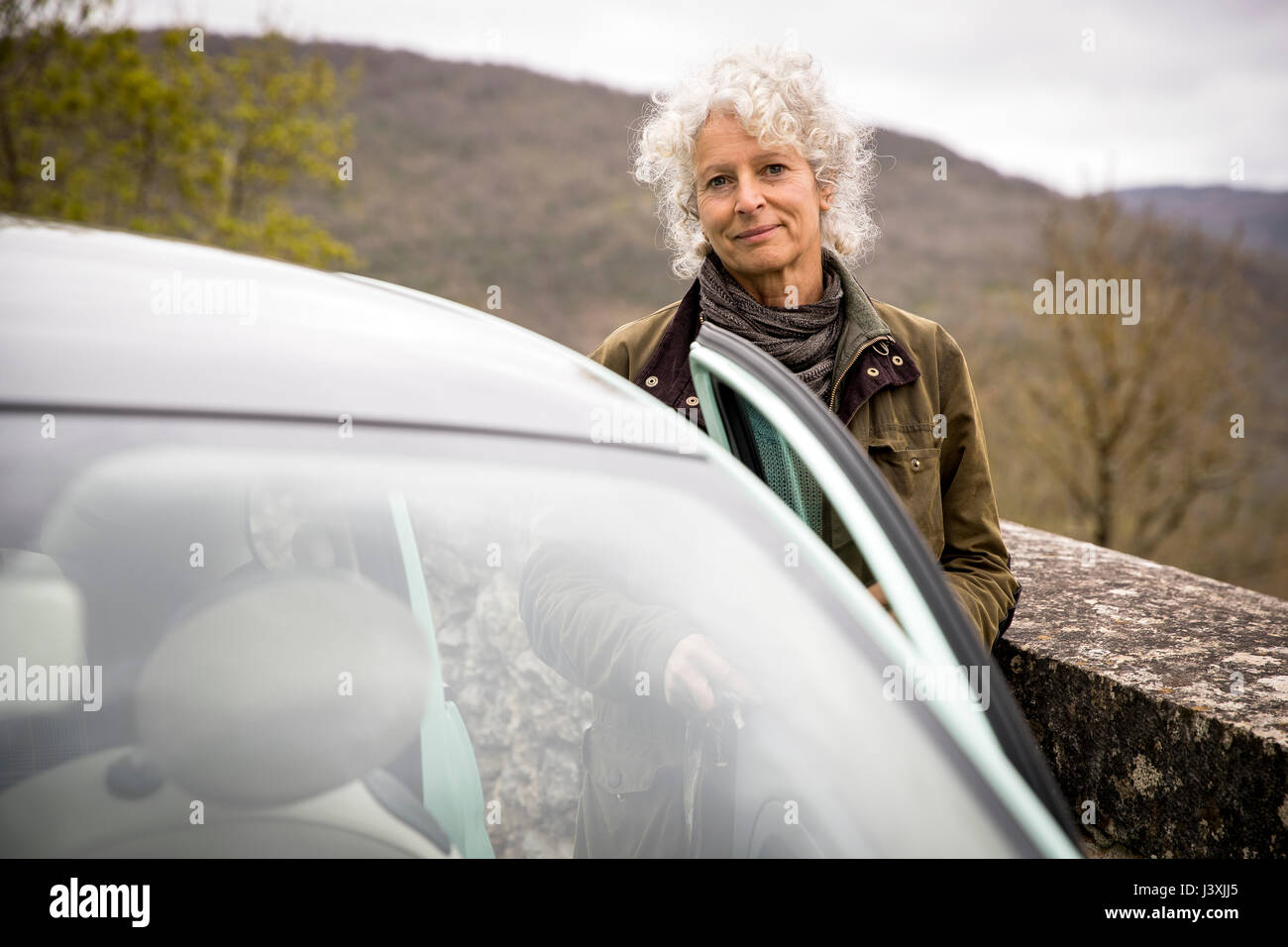 Woman getting into car Stock Photo - Alamy