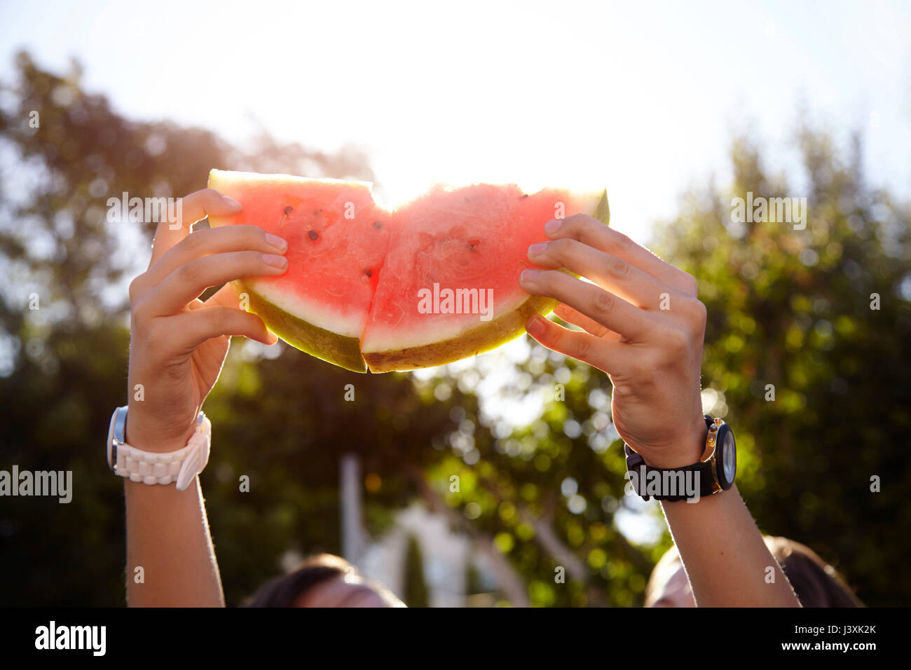 Teenage girls holding up watermelon in street Stock Photo - Alamy