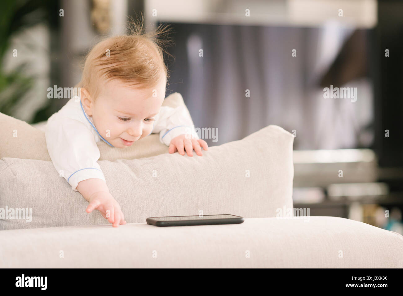 Baby looking interested in mobile phone Stock Photo - Alamy