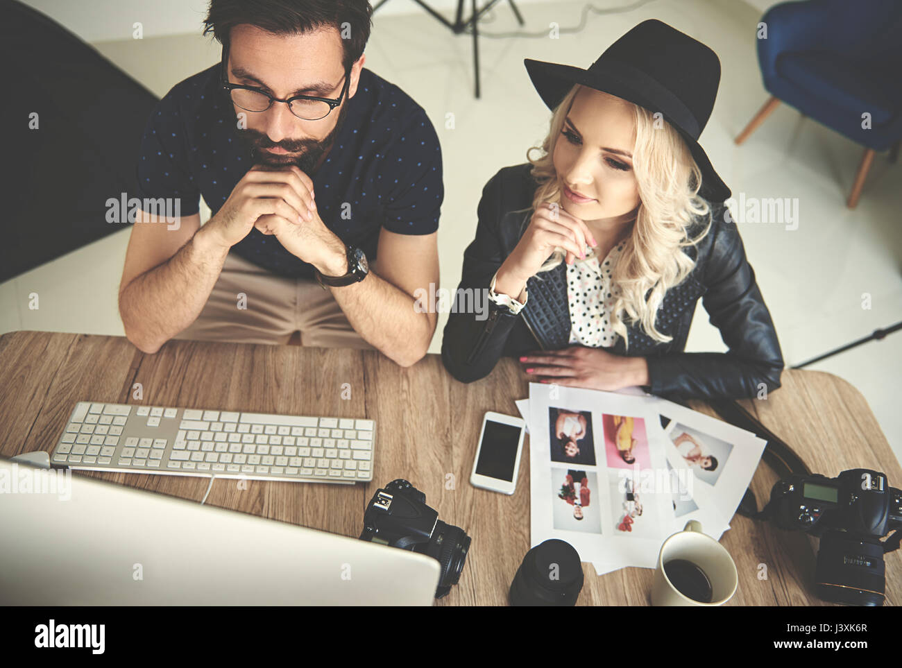 Photographer and stylist looking at photographs on photography studio ...