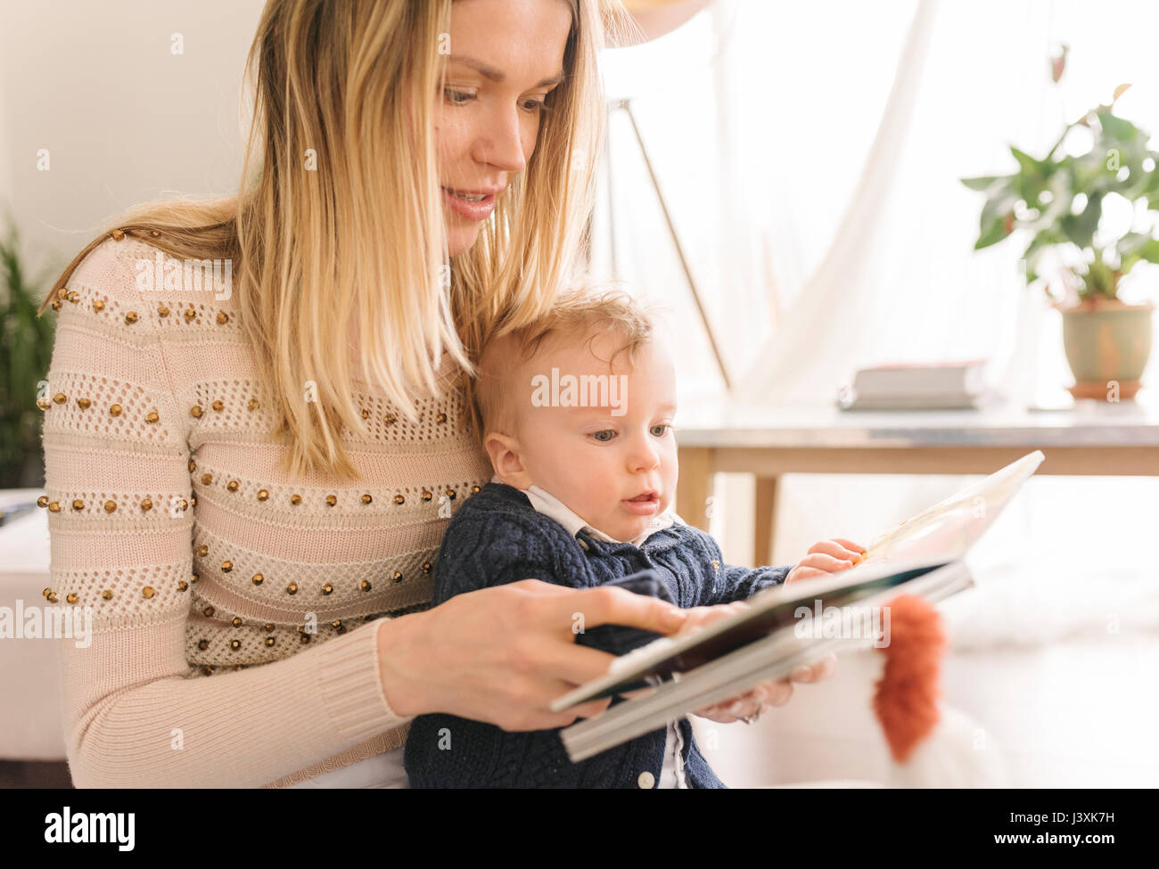 Mother holding and reading to baby Stock Photo - Alamy