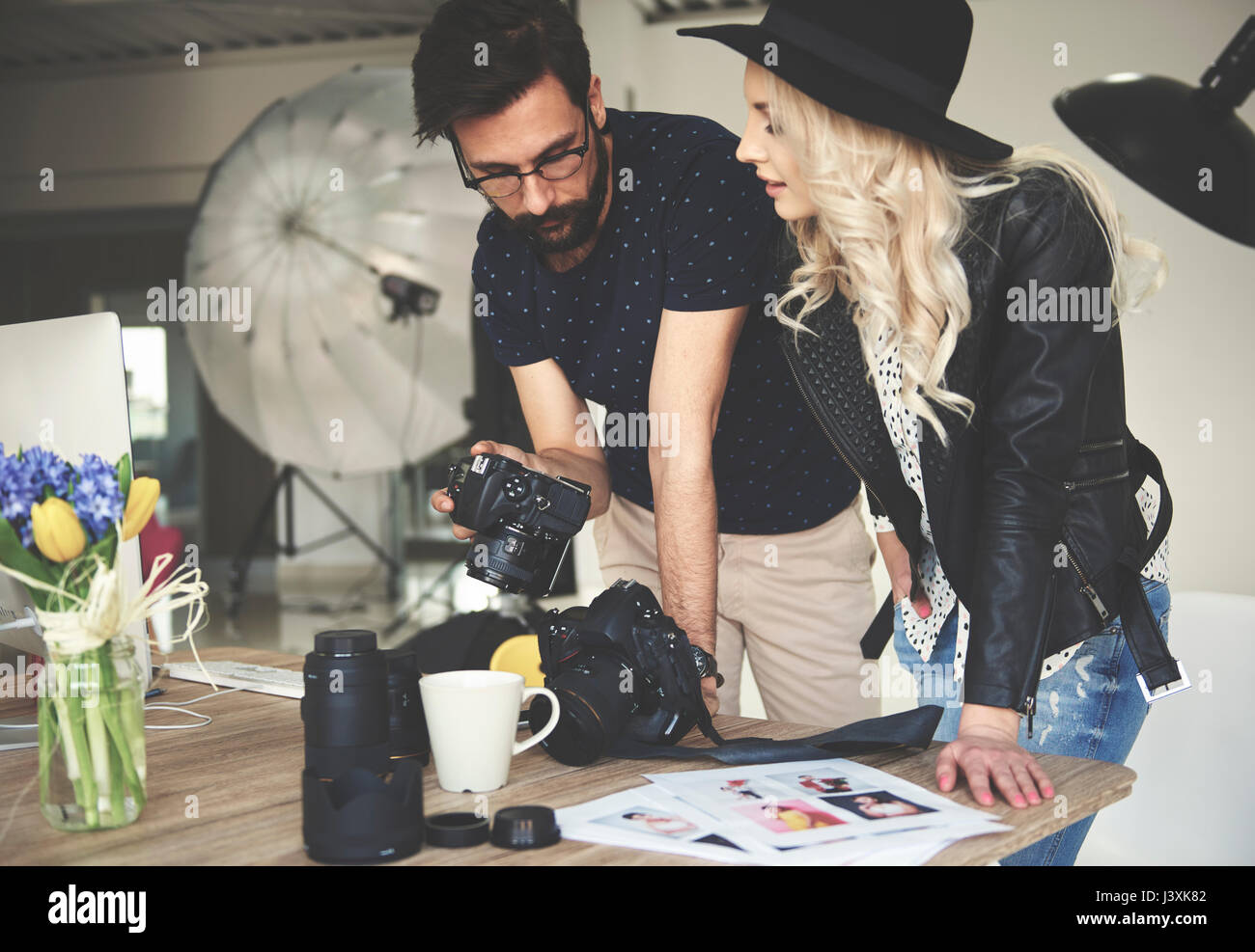 Photographer and stylist reviewing photographs on photography studio ...
