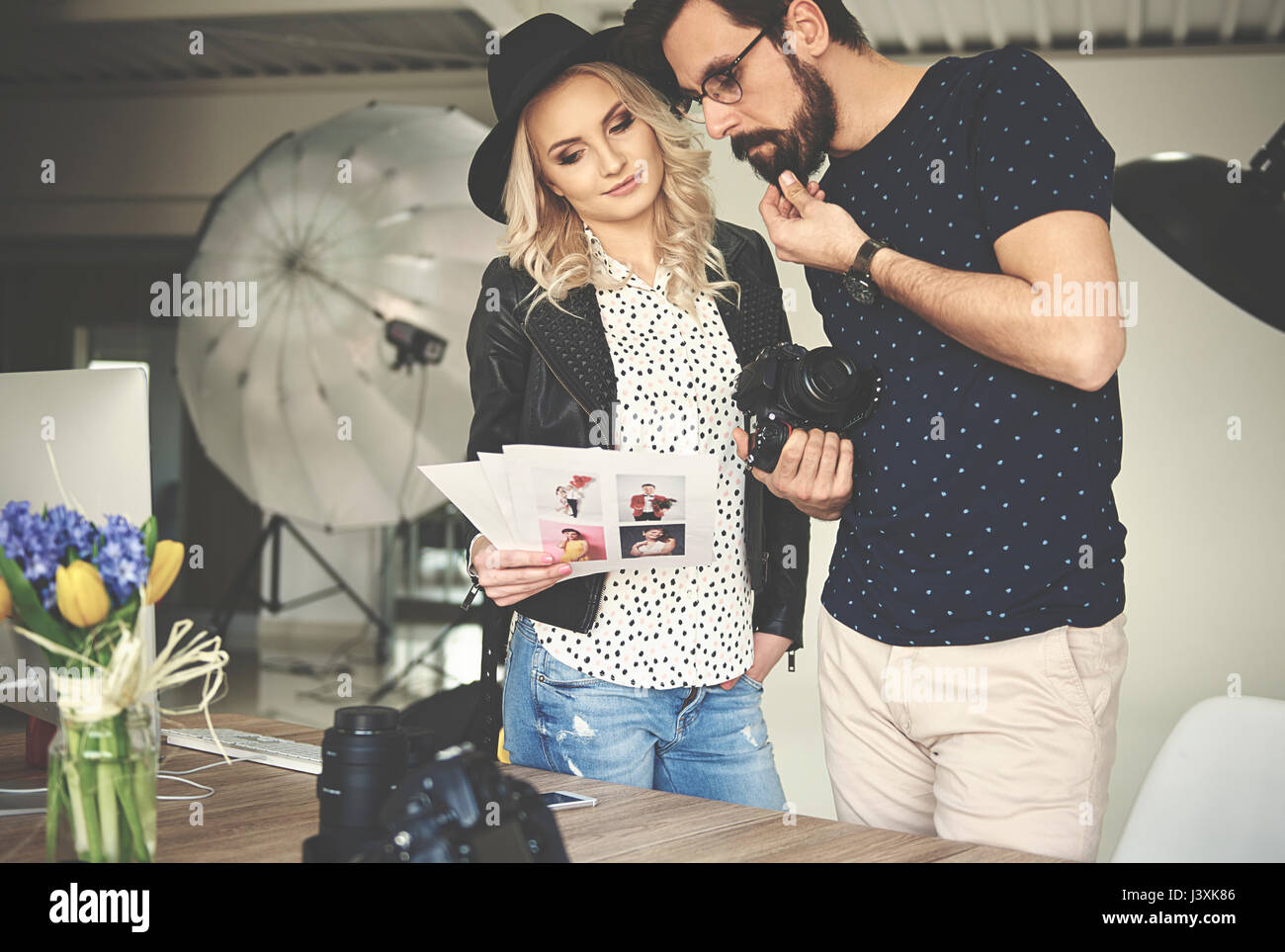 Photographer and stylist looking at photographs in photography studio ...