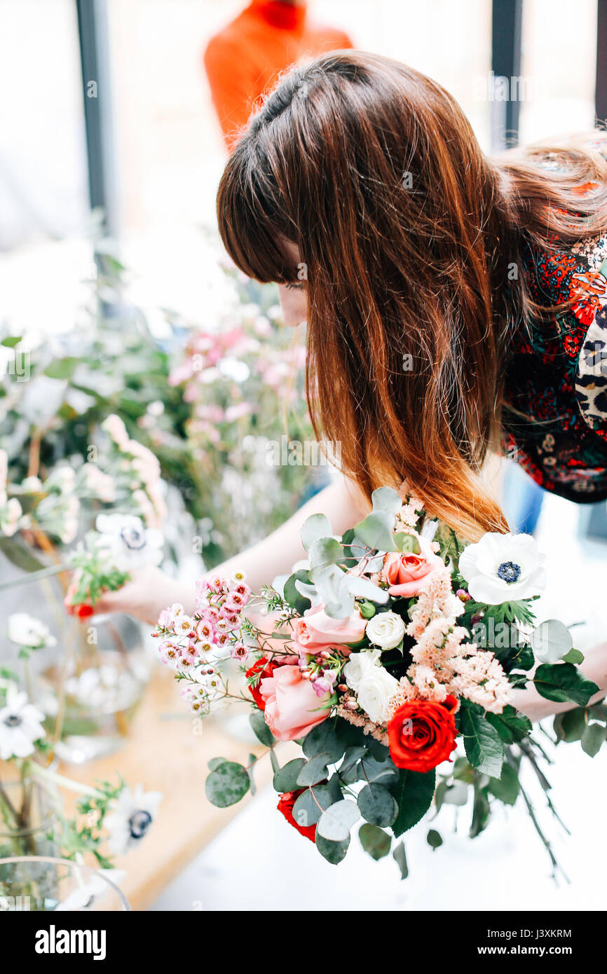 Florist student selecting cut flowers at flower arranging workshop ...