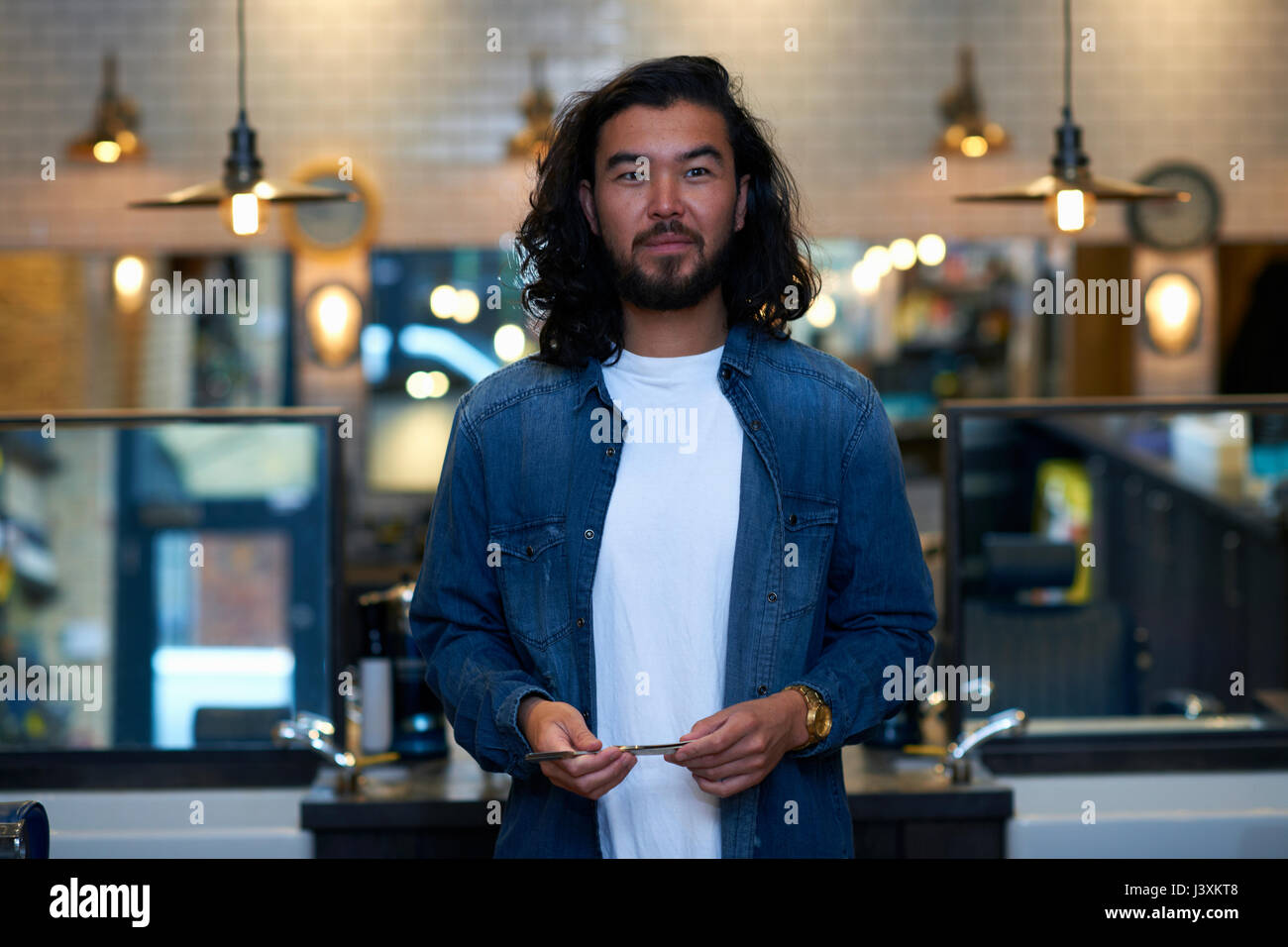Portrait of barber holding straight razor in retro style barber shop ...
