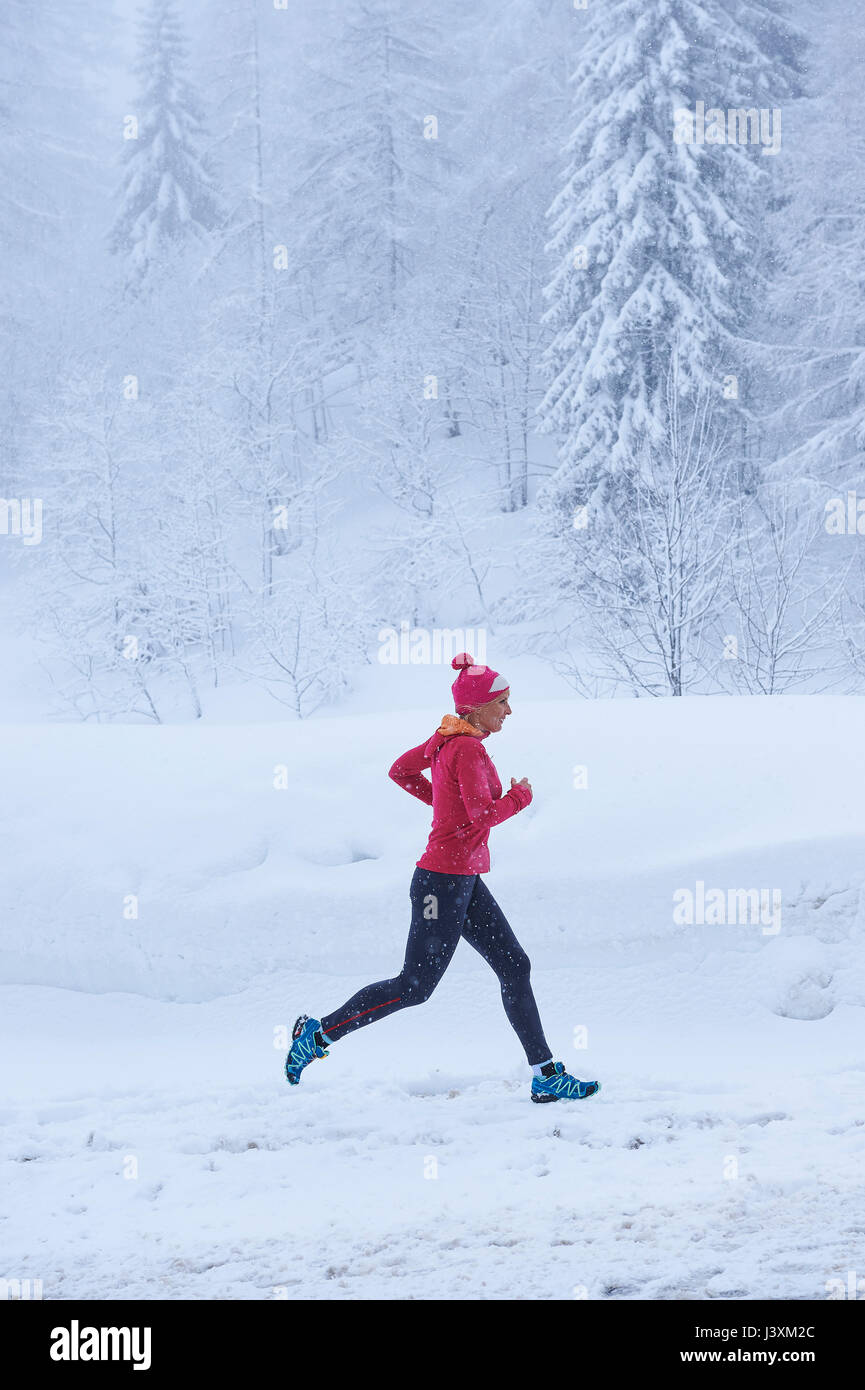Female runner running in deep snow, Gstaad, Switzerland Stock Photo - Alamy