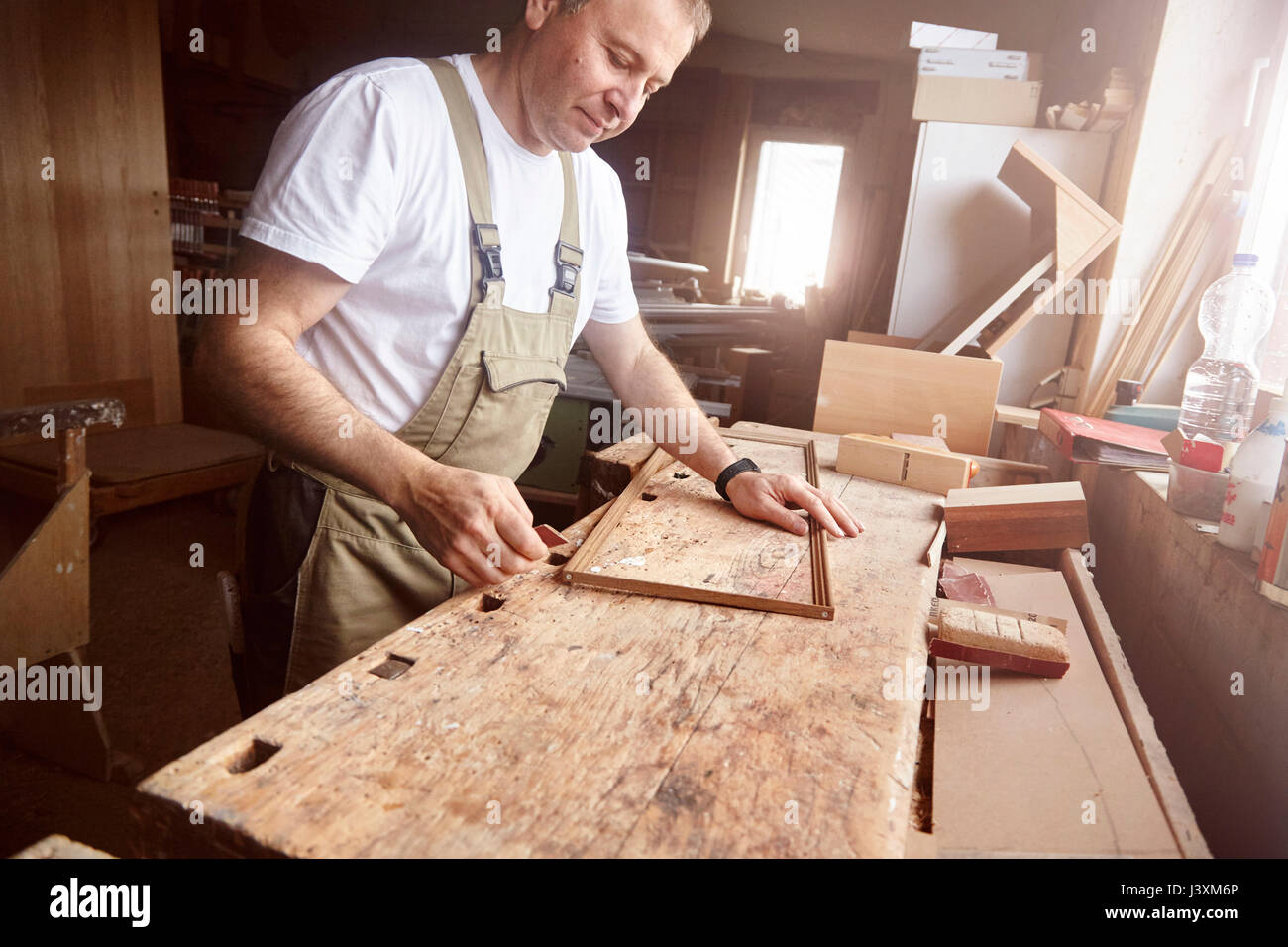 Male carpenter sanding picture frame at workbench Stock Photo - Alamy Male carpenter sanding picture frame at workbench Stock Photo - Alamy