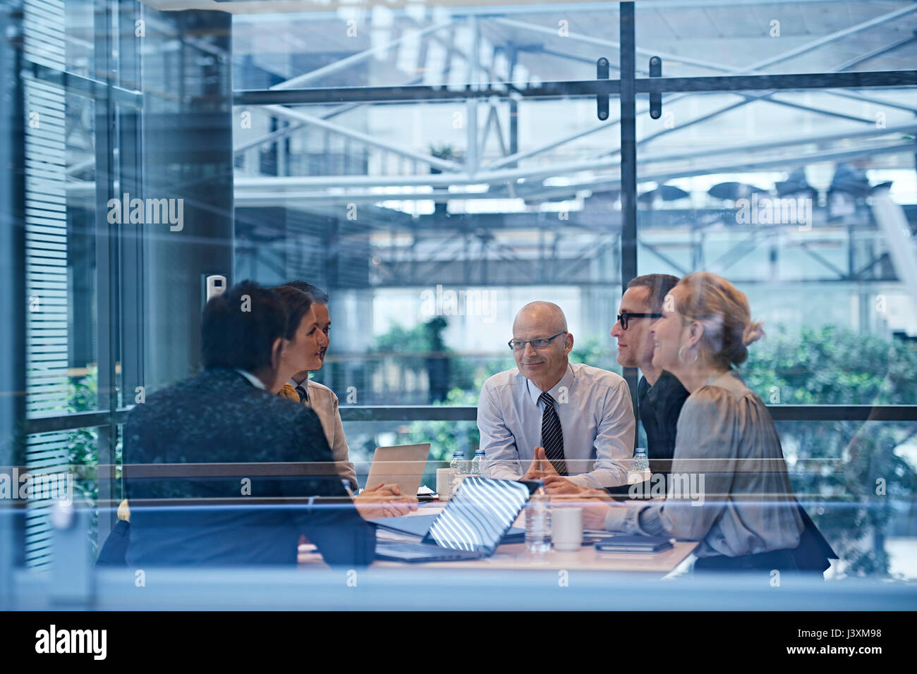 Window view of businesswomen and men having discussion in conference ...