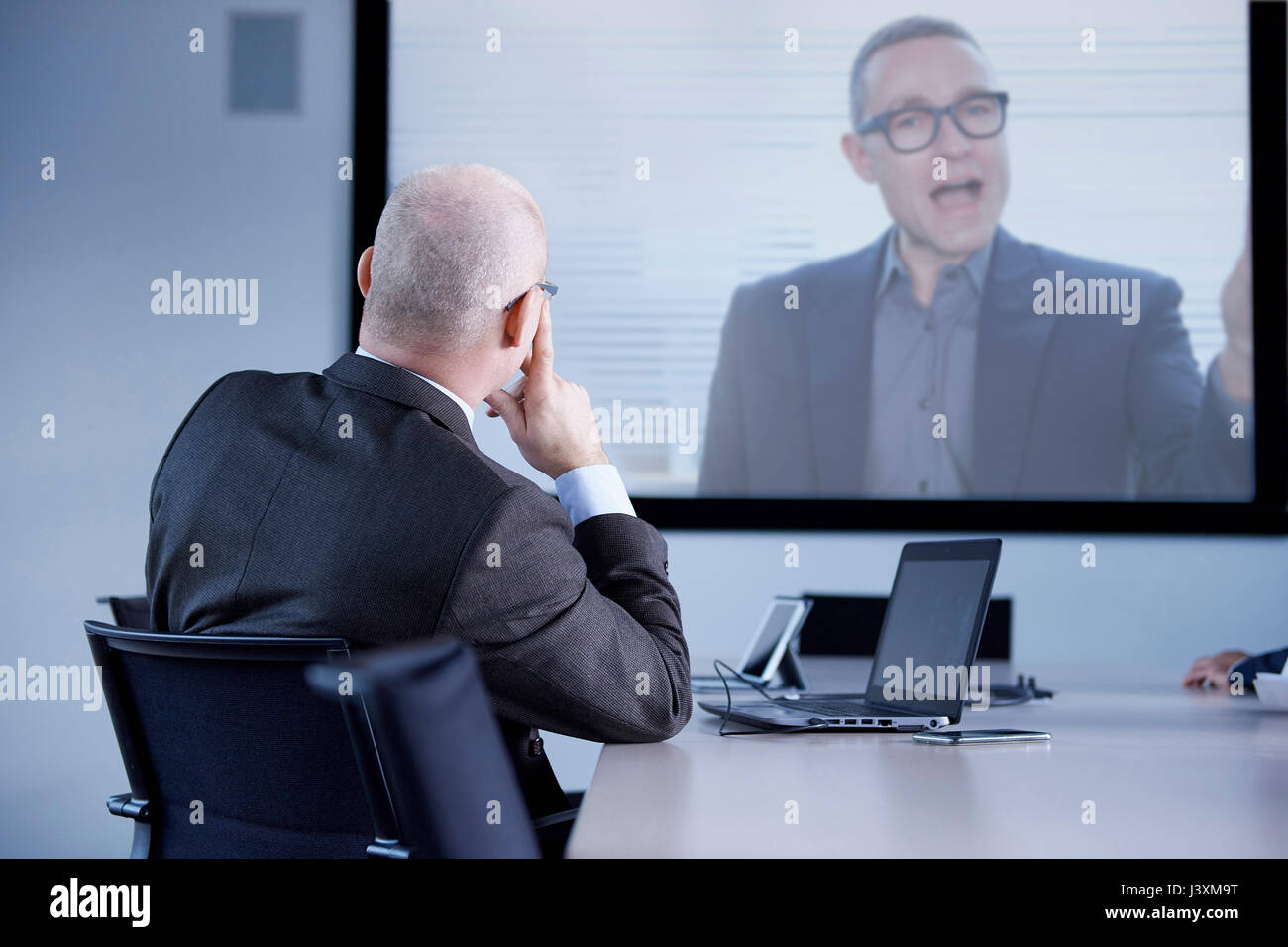 Businessman watching office conference call Stock Photo - Alamy