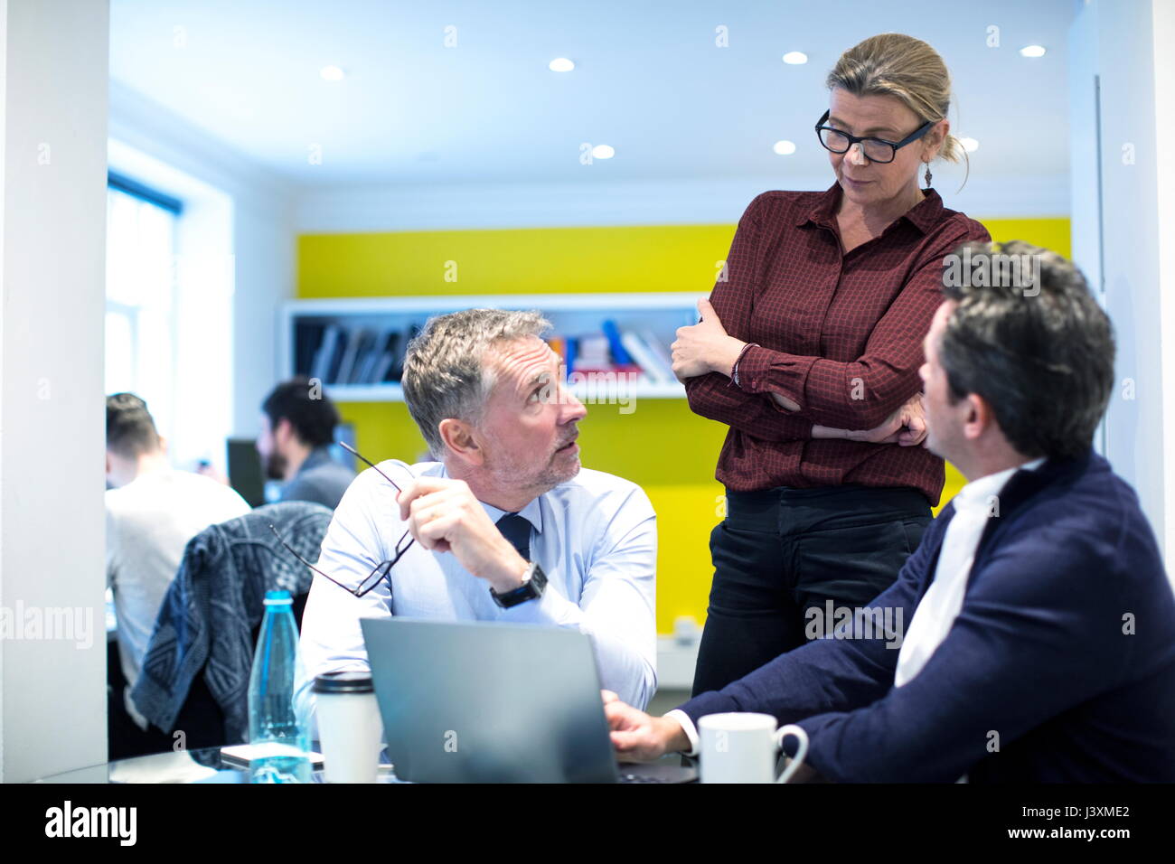 Discussing colleagues businesswoman using laptop hi-res stock ...
