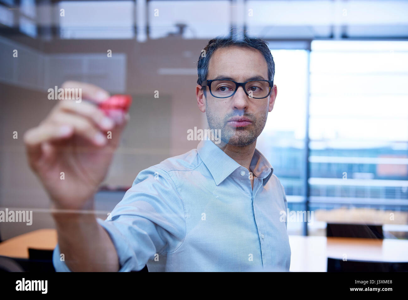 Businessman making presentation drawing graph on office window Stock ...