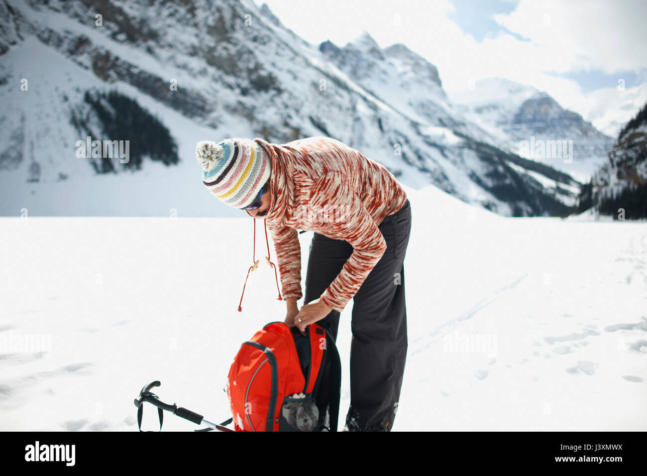 Hiker snow covered landscape preparing hiking equipment, Lake Louise ...