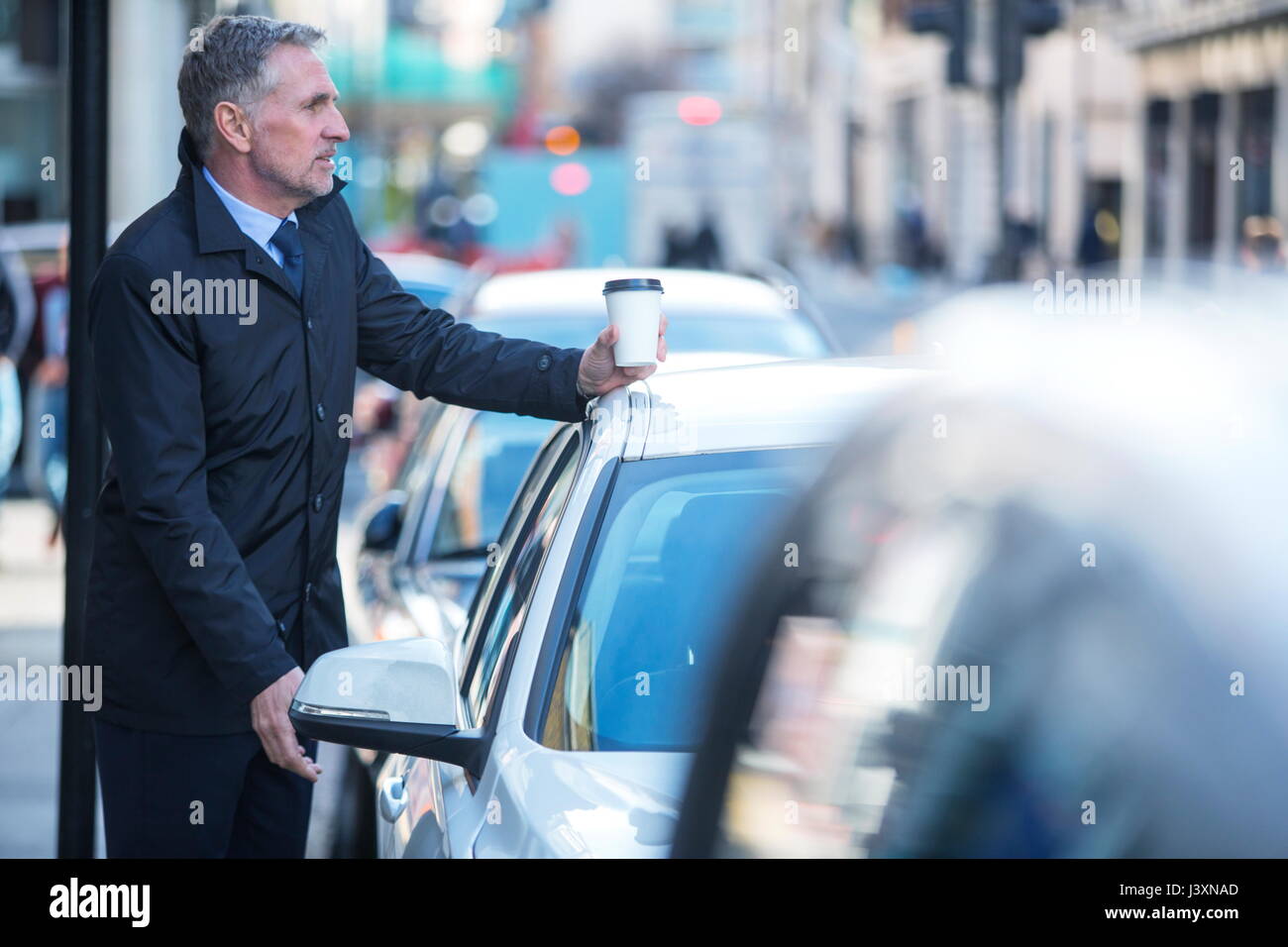 Man getting into car Stock Photo - Alamy